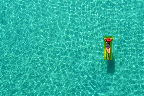 세이셸의 투명한 청록색 바다에서 수영 매트리스에서 수영하는 슬림 한 여성의 공중 보기 소녀와 여름 바다 풍경 아름다운 파도 다채로운 물 드론에서 보기 건강한 생활방식에 대한