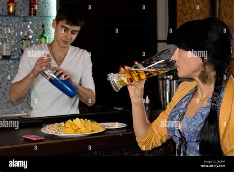 Barman Working Behind A Bar Counter In A Nightclub Mixing Cocktails