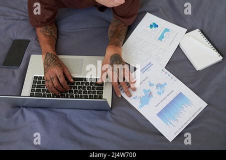 Varioius Charts And Diagrams On Bed Of Young Entrepreneur Working On