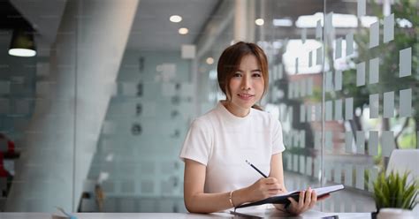 노트북을 들고 현대 직장에 앉아 카메라를 향해 웃고 있는 성공적인 사업가 사진 Unsplash의 태국 이미지