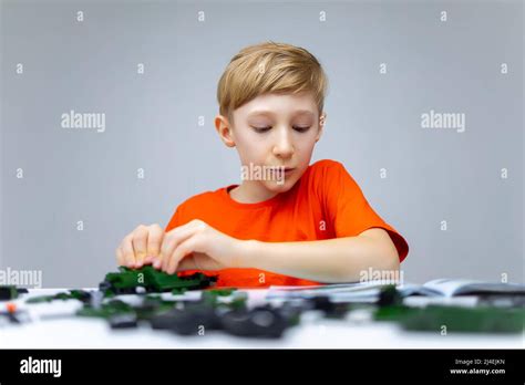 The Boy Is Playing With A Plastic Constructor He Will Make