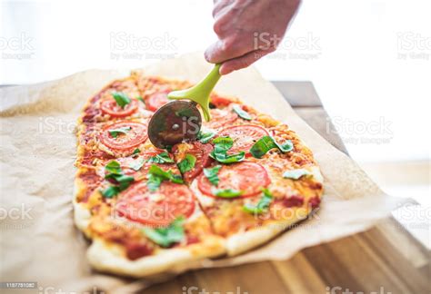 피자 커터를 사용하여 토마토와 바질로 맛있는 수제 피자를 손으로 자르기 나폴리 피자에 대한 스톡 사진 및 기타 이미지 나폴리 피자 독일 마르가리타 Istock