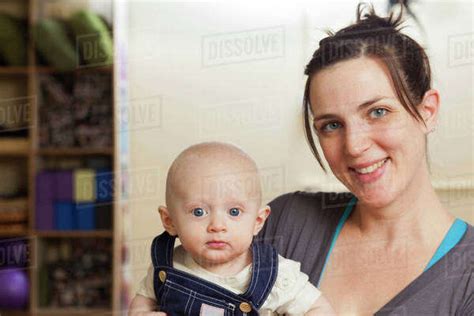 Caucasian Mother Holding Baby In Yoga Studio Stock Photo Dissolve