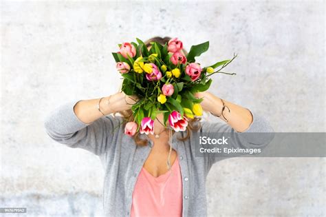 꽃의 부케와 함께 젊은 예쁜 여자 콘크리트 벽 앞에 서 서 하 고 어머니의 날 생일 결혼식에 대 한 행복 건강한 생활방식에 대한