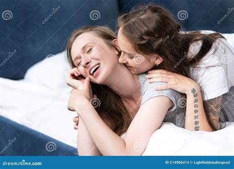 Two Lesbians Embracing With Closed Eyes While Lying On Bed In Morning