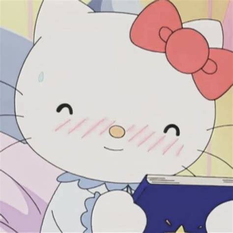 A Hello Kitty Sitting On Top Of A Bed Holding A Book