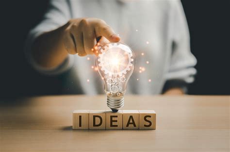 Word Ideas 전구로 나무 블록에 빛나는 전구를 만지는 여자 손 내부 톱니 바퀴 아이콘입니다 혁신적이고 고무적인 새로운 아이디어 과학 및 커뮤니케이션 개념의 기술 혁신