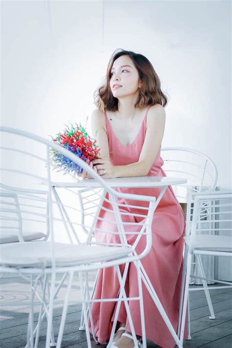 Woman In Pink Dress Sitting On Chair Picture Image 119844894