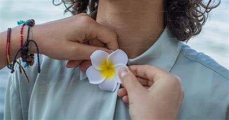 한 여자가 다른 여자의 셔츠에 꽃을 꽂고 있다 사진 Unsplash의 꽃 이미지