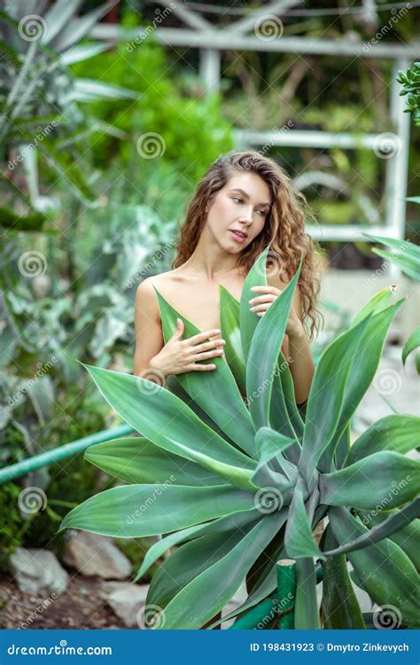 Naked Woman Standing Near The Plant And Looking Thoughtful Stock Image
