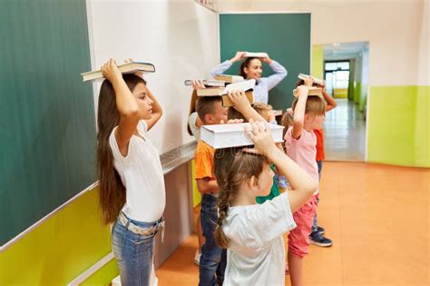 School Students Holding Book Overhead In Class Stock Photo Image Of