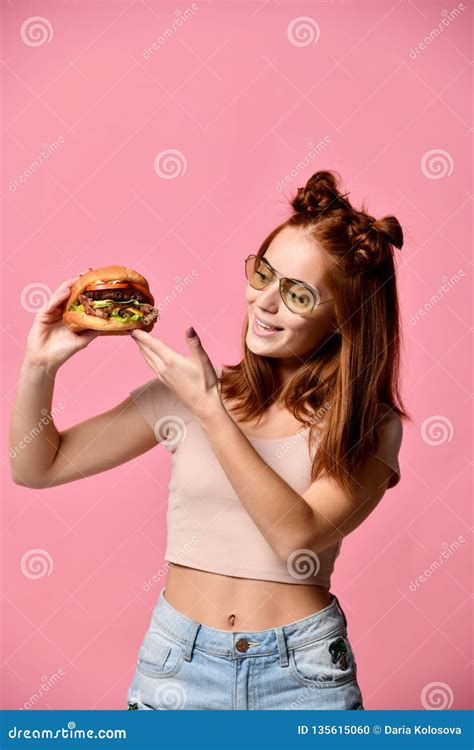 Close Up Portrait Of A Hungry Young Woman Eating Burger Isolated Over