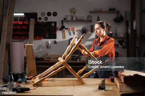 오래된 가구의 개조 및 복원을 위한 중소기업 및 목수 작업장의 개념 젊은 아름 다운 여자 샌딩 특수 스폰지로 나무 의자 25