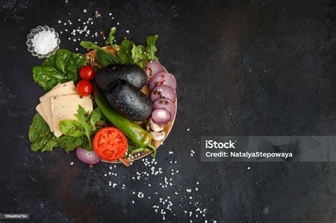 어두운 배경에서 야채 햄버거 또는 샐러드 치즈 신선한 채소 Arugula 근대 고추 칠리 토마토 체리 오이 양파 신선한 빵에 대