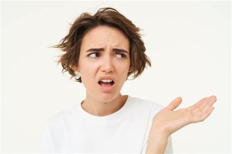 Retrato de una joven decepcionada quejándose sosteniendo la mano de lado hablando expresa