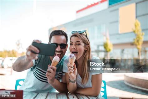 아름 다운 젊은 부부 그들은 야외에서 앉아 있다 하는 동안 Selfie를 복용 및 코 넷에 얼음크림을 데 아이스크림에 대한 스톡