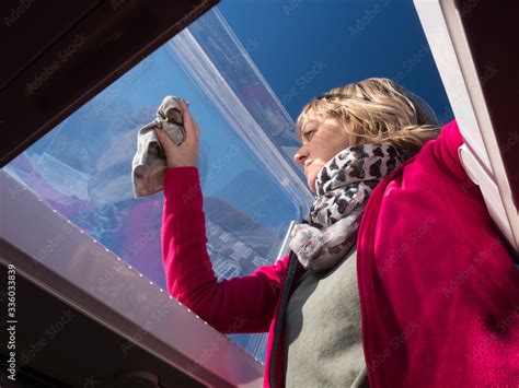 A Lady Motorhome Owner Cleans The Skylight Hatch Of Her Recreational