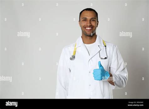 Doctor Or Medical Assistant Male Nurse In Uniform Showing Thumb Up On