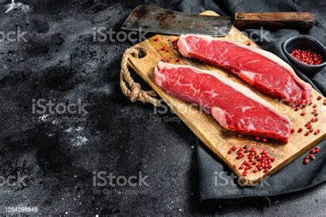 도마에 허리 스테이크를 스트립 유기농 쇠고기 고기 검은 색 배경 맨 위 보기입니다 복사 공간 0명에 대한 스톡 사진 및 기타