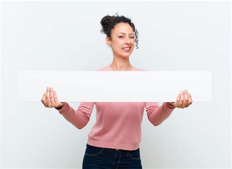 Joven Mujer Bonita Con Un Cartel Contra La Pared Blanca Foto Premium