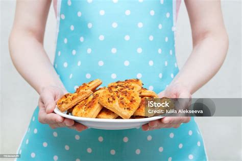 주방 앞치마의 소녀는 그녀의 손에 쿠키와 흰 접시를 보유 하 고 있습니다 클로즈업 앞치마에 대한 스톡 사진 및 기타 이미지 앞치마 요리하기 음식 준비 접시 Istock