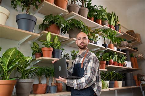 꽃 가게에서 꽃집 주인 꽃 가게를 걷고 노트북으로 상점의 재고를 확인하는 꽃집 주인은 상점의 주인입니다 고객에 대한 스톡 사진 및 기타 이미지 Istock