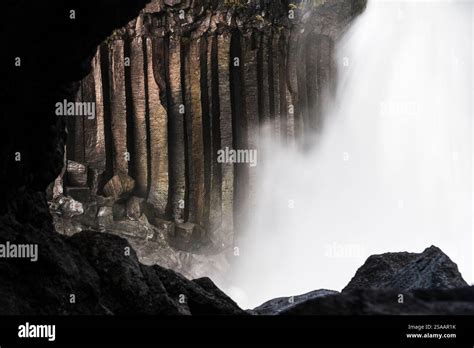 Water Cascades Dramatically Over Towering Hexagonal Basalt Columns Creating A Misty Atmosphere Water Cascades Dramatically Over Towering Hexagonal Basalt Columns Creating A Misty Atmosphere