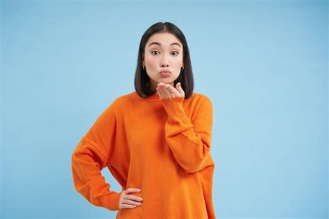 Free Photo Cute Young Woman Puckers Her Lips And Blows Air Kiss At