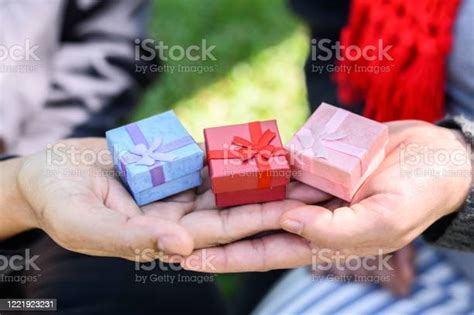 사랑스러운 부부의 자른 샷 이미지 남편은 결혼을 축하하기 위해 아내에게 작은 선물 상자를 제공합니다 선물 가게에 대한 스톡 사진