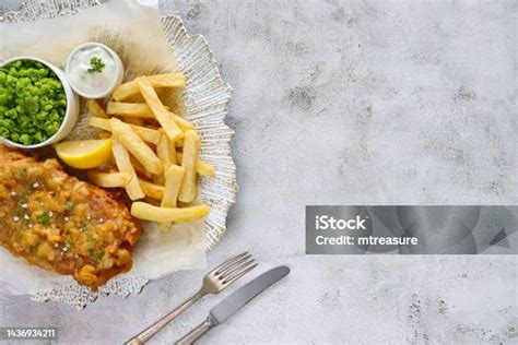 레몬 슬라이스 타르타르 소스 부드러운 완두콩 나이프와 포크 대리석 효과 배경 높은 보기 복사 공간과 함께 제공되는 기름칠 양피지가 있는 불규칙한 테두리가 있는 흰색 금색