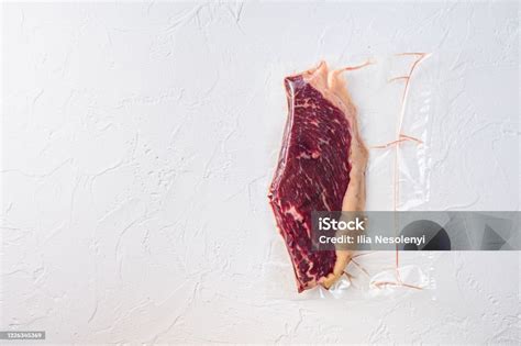 원시 피칸하 스테이크 진공 흰색 콘크리트 질감 배경에 유기농 쇠고기 고기를 포장 텍스트에 대한 상단 보기 공간 피카냐에 대한