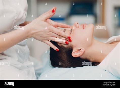 Beautiful Young Woman Getting Face Treatment Massage At Beauty Spa