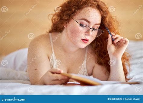 Pretty Half Naked Redhead Woman Make Notes Lying On Bed Stock Photo