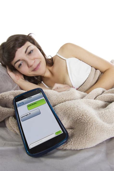 Unhappy Teenage Girl Sending Text Message Whilst Lying In Bed Stock