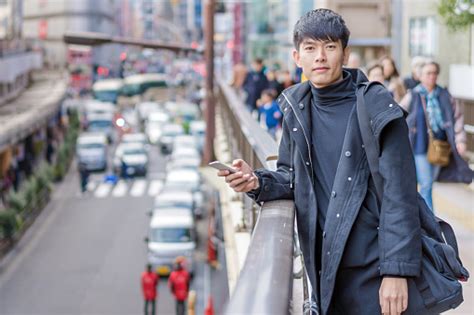 젊은 일본 남자와 아시아 친구 찾고 여행 위치 휴대 전화를 사용 하 고 일본에서 함께 시간을 보내는 2명에 대한 스톡 사진 및