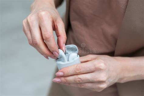 White Wireless Earphones In Ear Or Earbud Bluetooth With Charging Case Holding In Hand On White