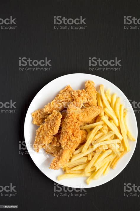 검은 표면에 흰색 접시에 집에서 만든 바삭한 치킨 텐더와 감자 튀김 상단 보기 텍스트 공간입니다 0명에 대한 스톡 사진 및 기타