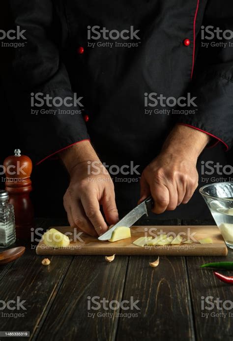 국가 요리를 준비하기 전에 요리사는 생 감자를 칼로 작은 조각으로 자른다 레스토랑 주방에서 일하는 동안 요리사 손을