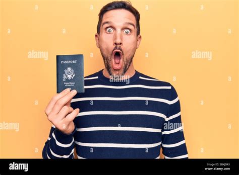 Young Handsome Tourist Man Holding United States Passport Over Isolated