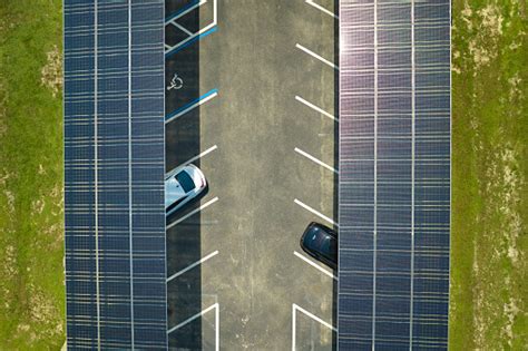 깨끗한 전기의 효과적인 생성을 위해 주차 된 자동차를위한 주차장 위에 그늘 지붕으로 설치된 태양 전지 패널의 조감도 도시 인프라에 통합 된 태양 광 기술 태양열 발전소에