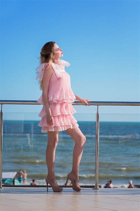 Een Aantrekkelijk En Mooi Wijfje In Een Roze Kleding Stelt Op Een