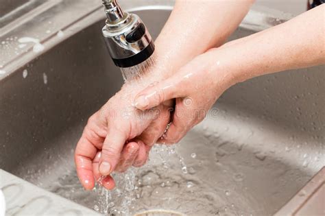 La Mujer Se Lava Las Manos Debajo De Un Golpecito Del Agua Foto De