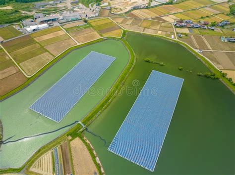 Solar Panels Float On Water In Irrigation Reservoir By Rice Fields And