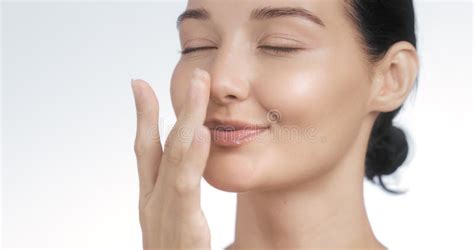 Young Woman Applying Skincare Cream With Eyes Closed Radiant Skin