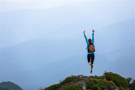 백 자루와 빨간 머리 소녀는 절벽의 가장자리에 높은 산 행복에서 한쪽 다리에 점프 위치 카 르 파 티아 산맥 Marmarosy 우크라이나입니다 개념에 대한 스톡 사진 및