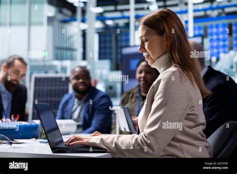 Photovoltaics Factory Management Team Analyzing Data Using Laptop Reviewing System Health