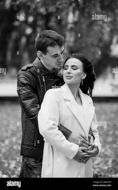 A Man Hugs His Pregnant Wife A Man In A Black Jacket Hugs A Woman In A