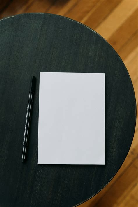 펜 옆 테이블 위에 놓인 종이 한 장 사진 Unsplash의 무료 회색 이미지