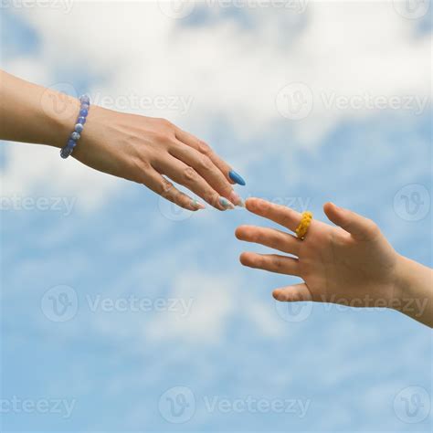 Two Hands Reaching Out To One Another Almost Touching In Front Of