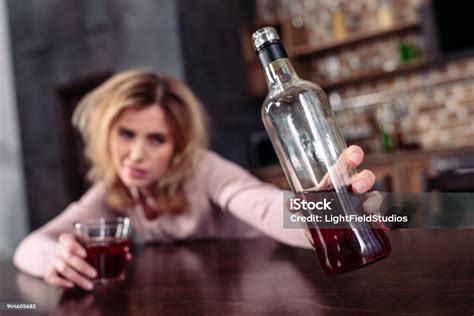 술 취한 여자 집에서 테이블에 앉아있는 동안 알코올의 복용 병의 선택적 초점 가정 생활에 대한 스톡 사진 및 기타 이미지 가정 생활 고독 부정적인 감정 표현 마실 것
